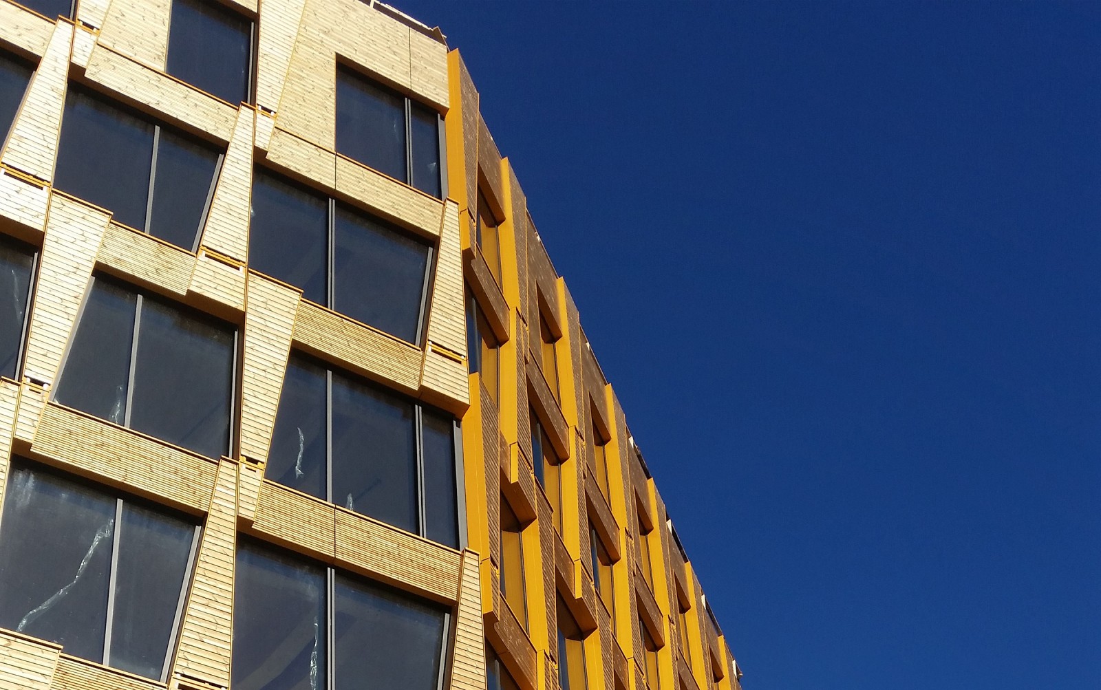How to use wood as a visible exterior material in a unitized element facade